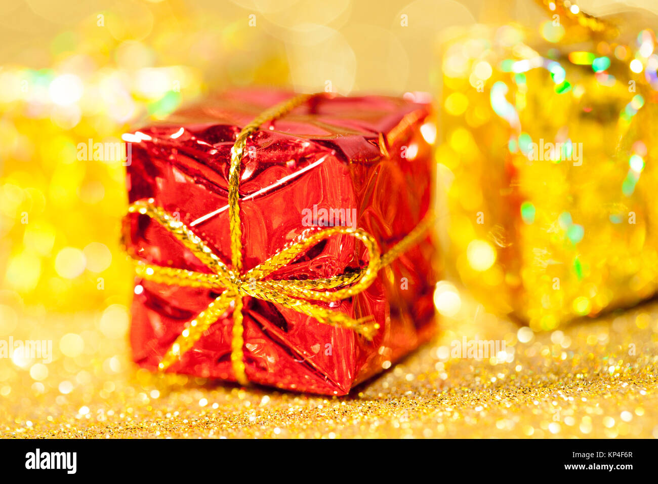 red and gold gift box with out of focus lights on a golden background ...