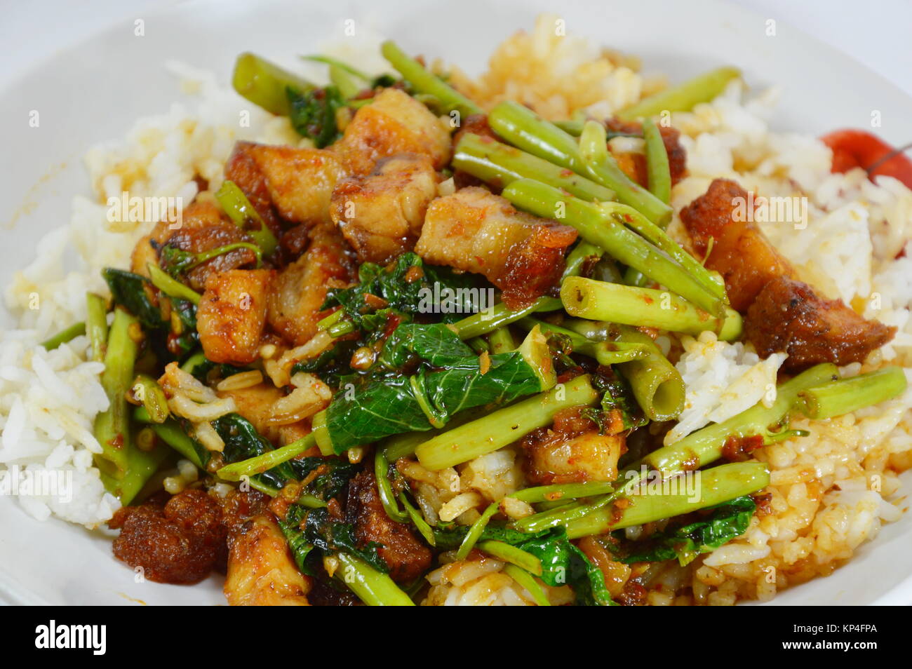 stir fried morning glory with crispy pork curry topping on plain rice ...