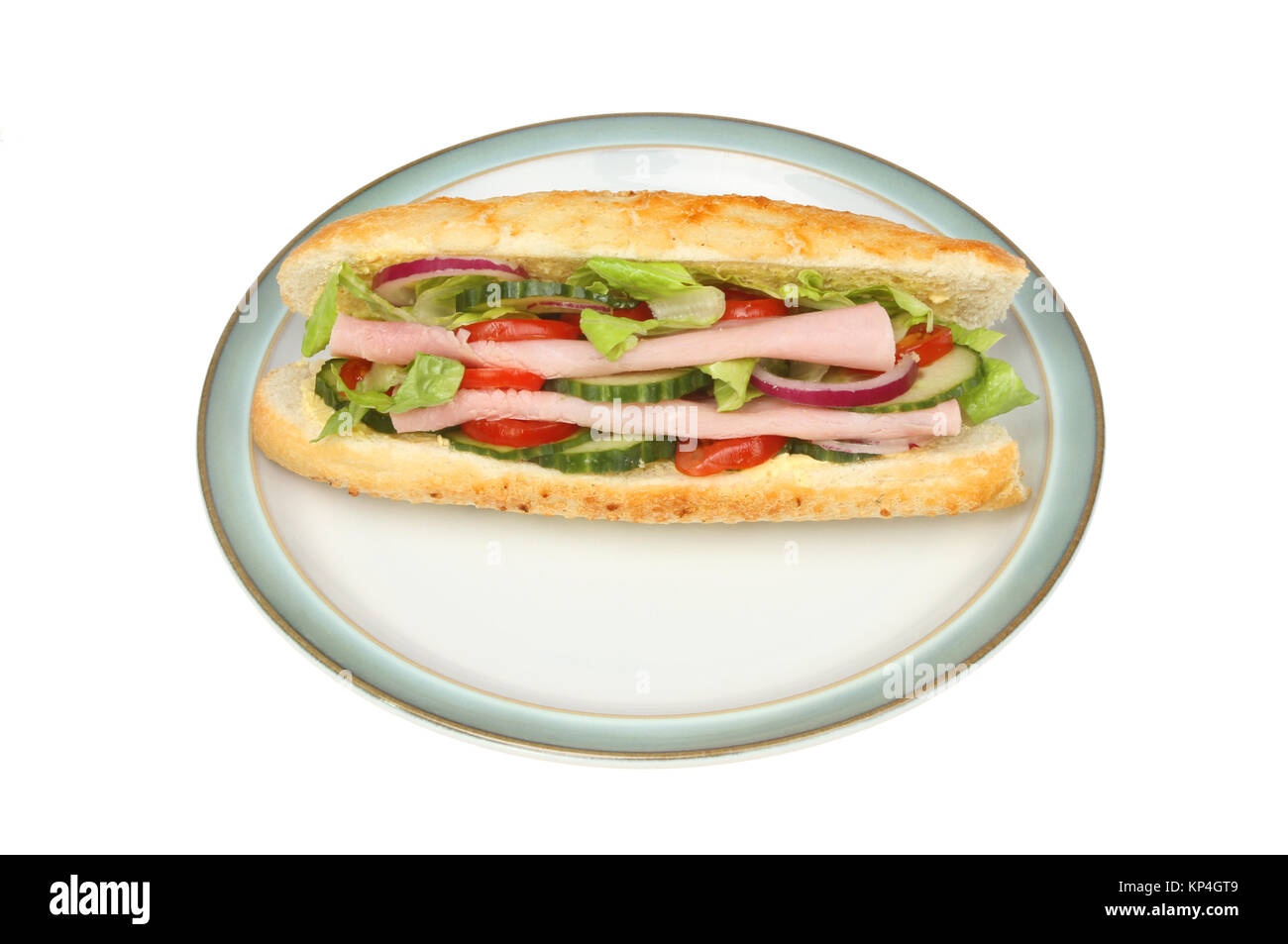 Ham and salad in a giraffe bread roll on a plate isolated against white ...