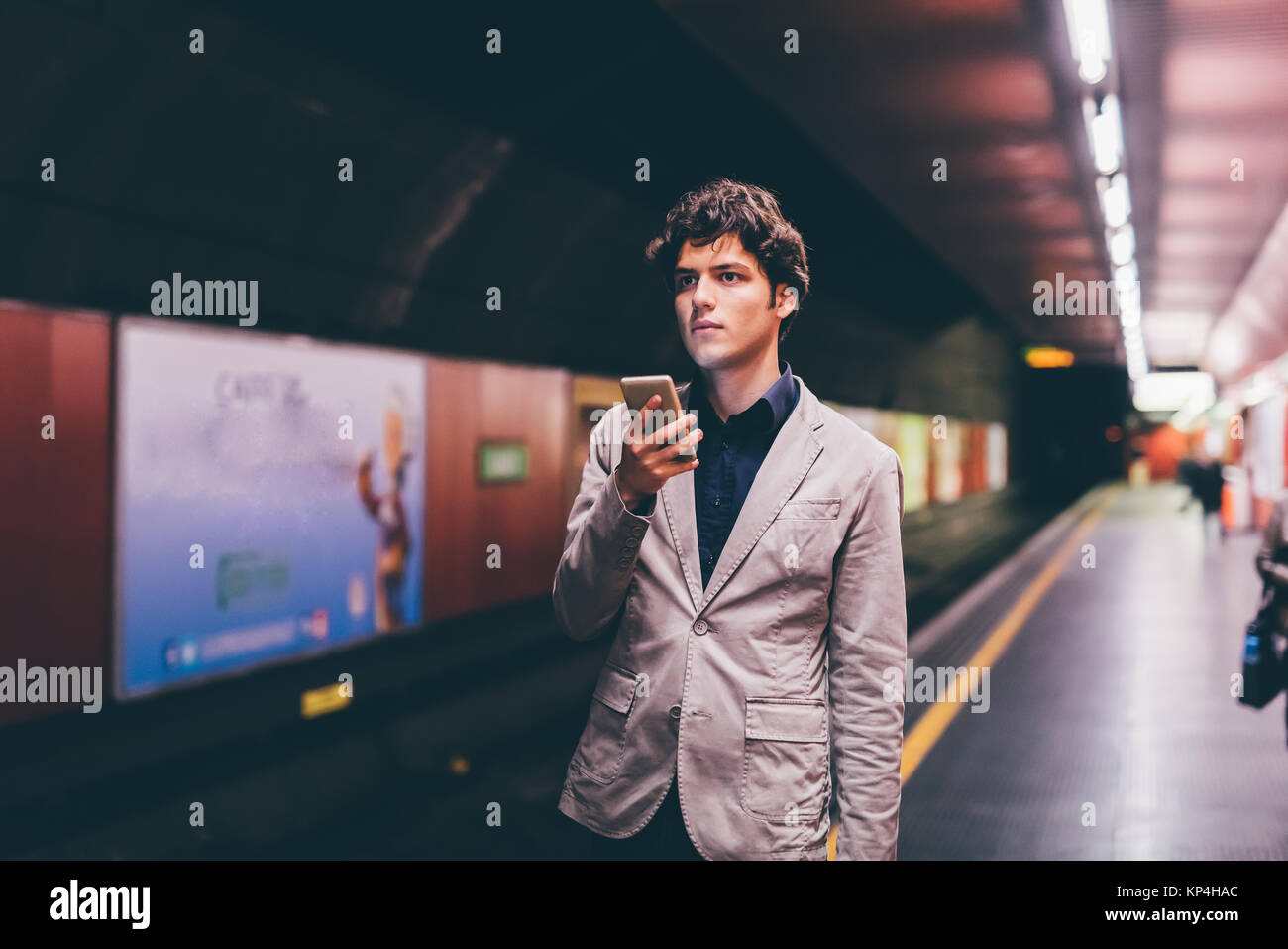 young man in the underground using smart phone - technology, waiting ...