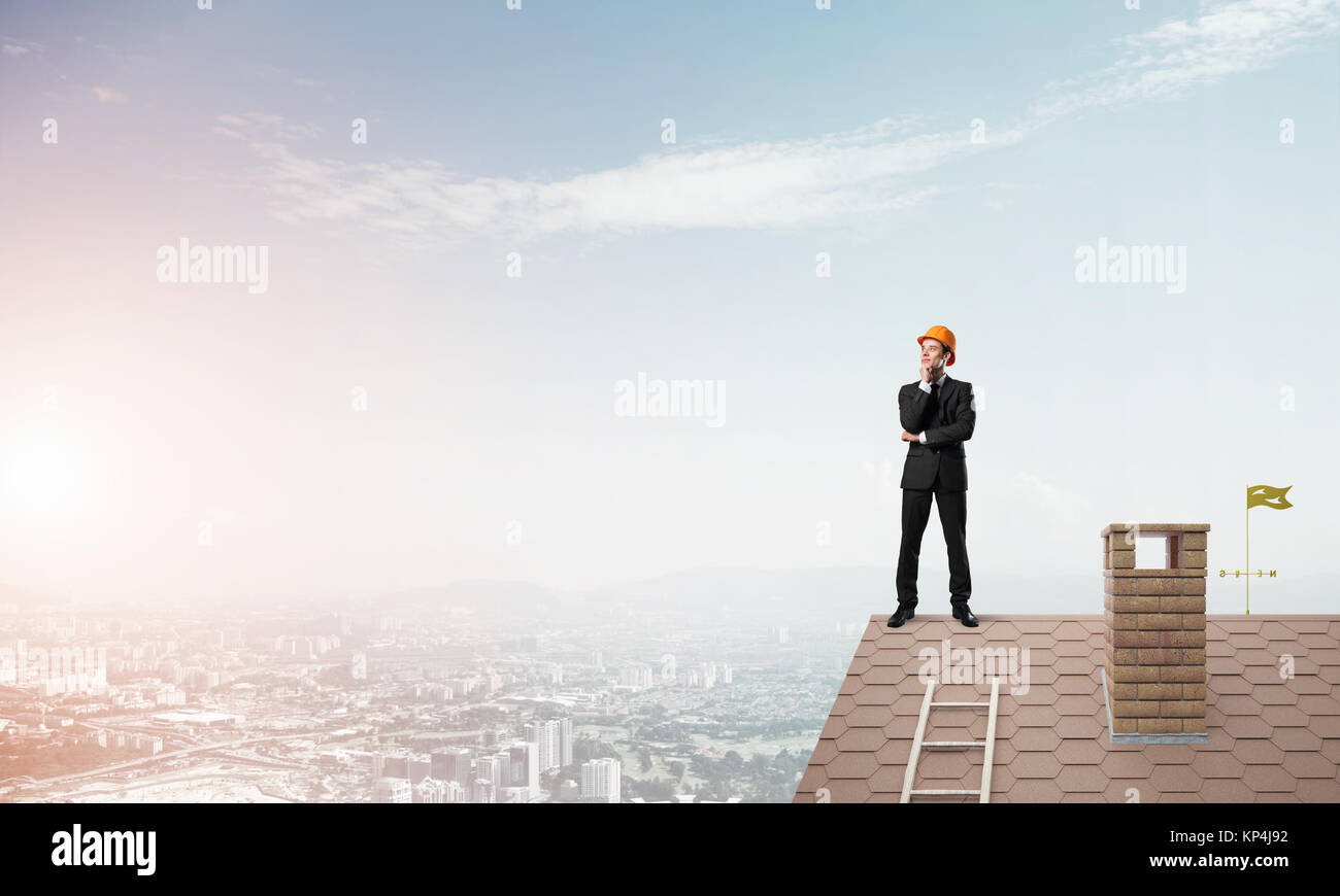 Engineer man standing on roof and looking away. Mixed media Stock Photo ...