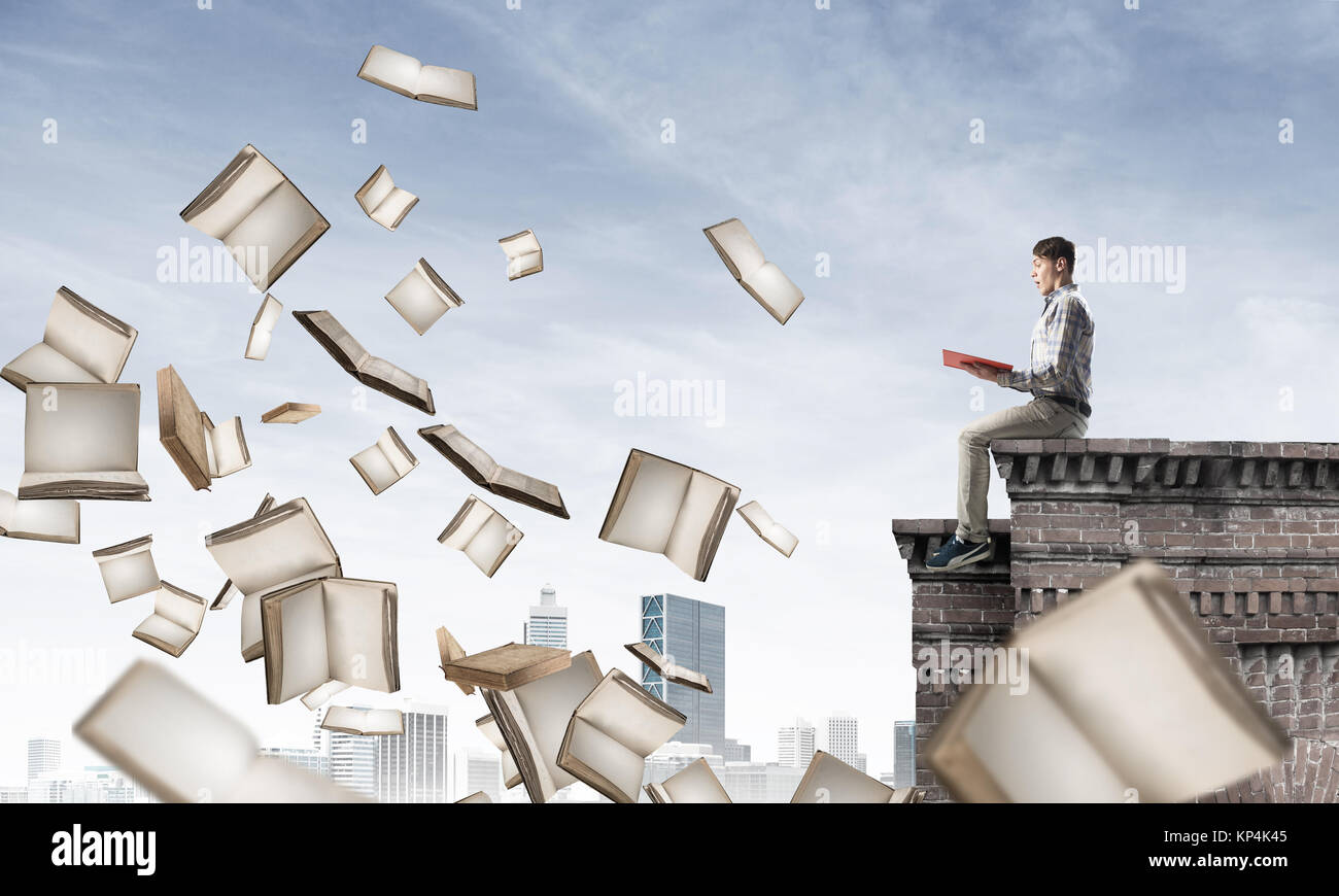 Man reading book and many of them flying in air Stock Photo - Alamy
