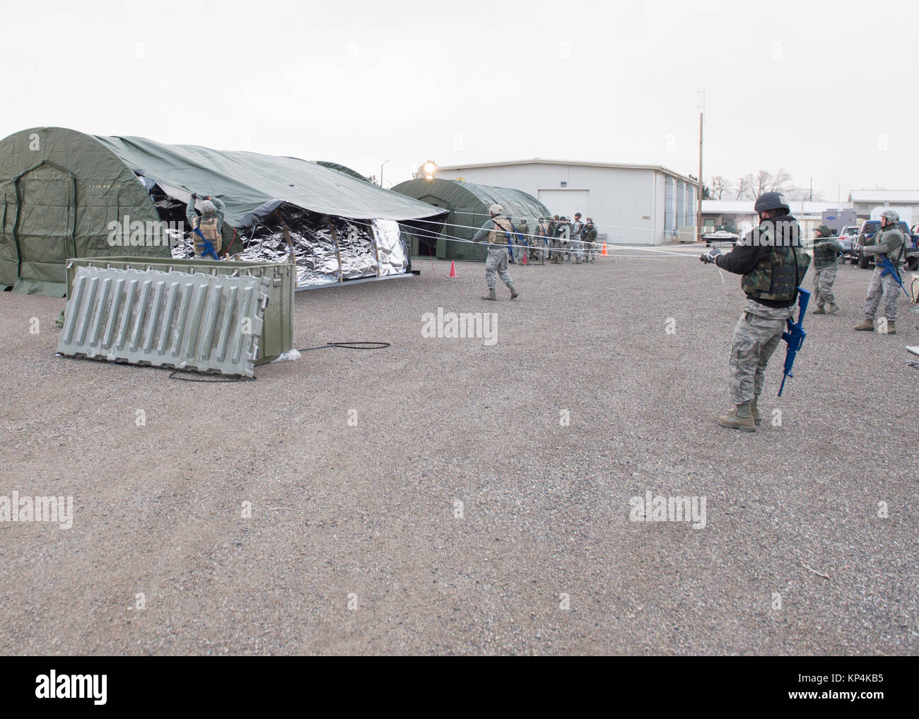 Airmen from the 366th Civil Engineer Squadron pull a tarp over a tent ...