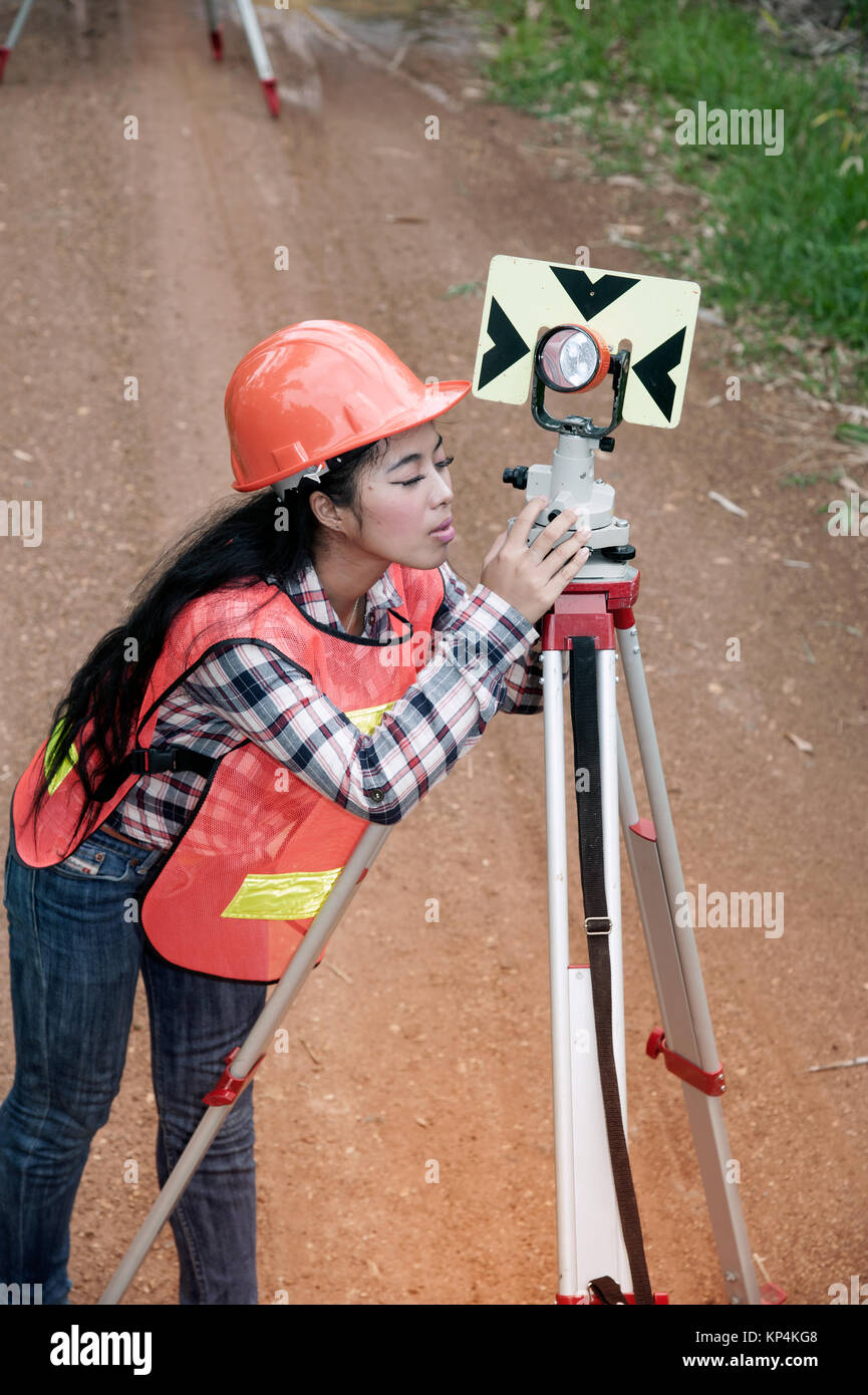 Female Surveyor or Engineer making measure by prism reflector on the ...