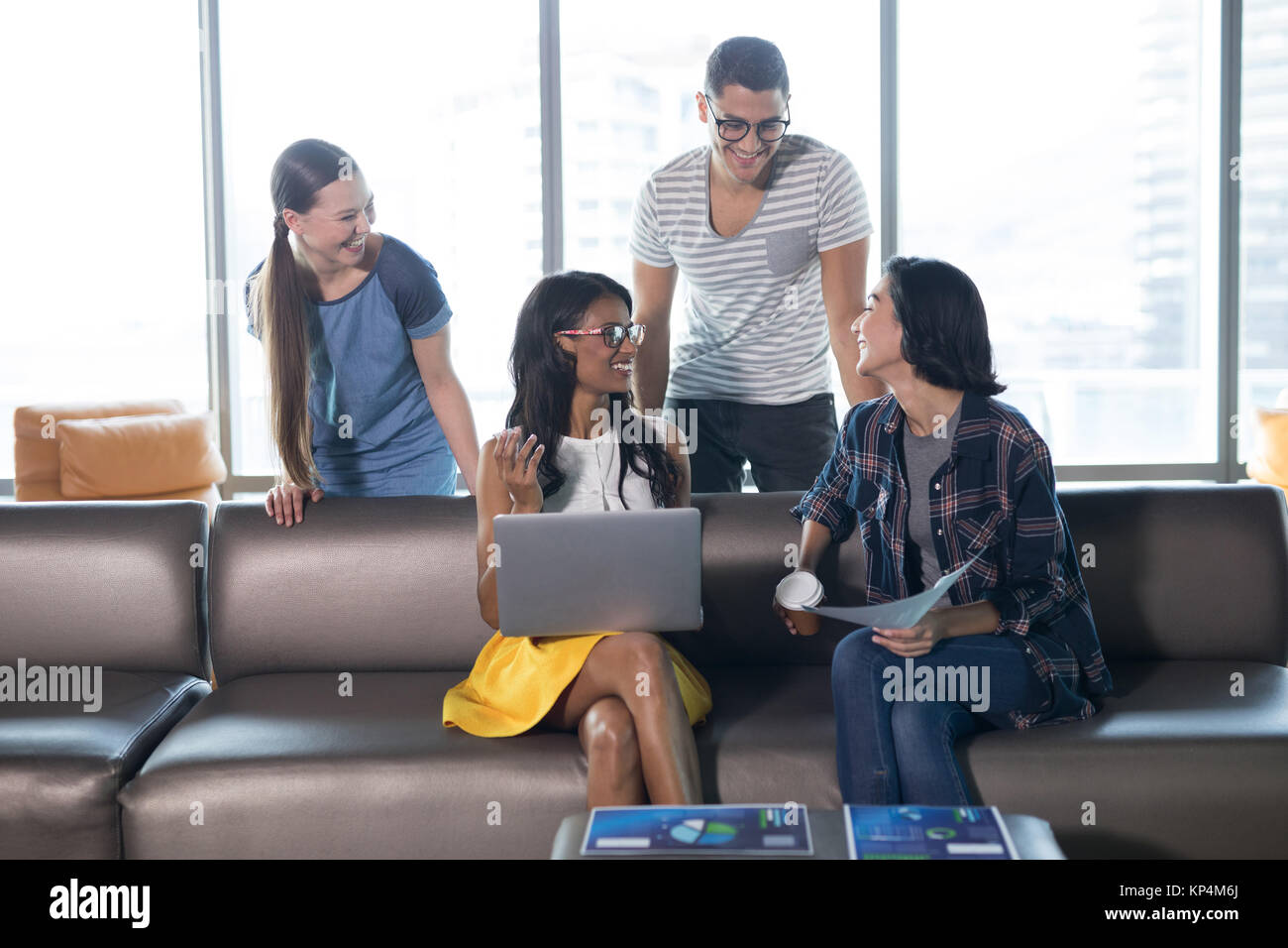 Smiling executives interacting while working together in office Stock ...