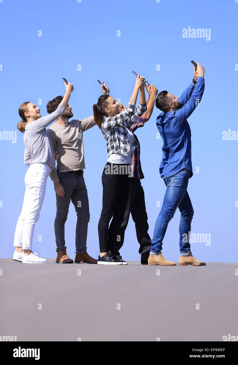 rear view. happy friends doing a selfie Stock Photo - Alamy