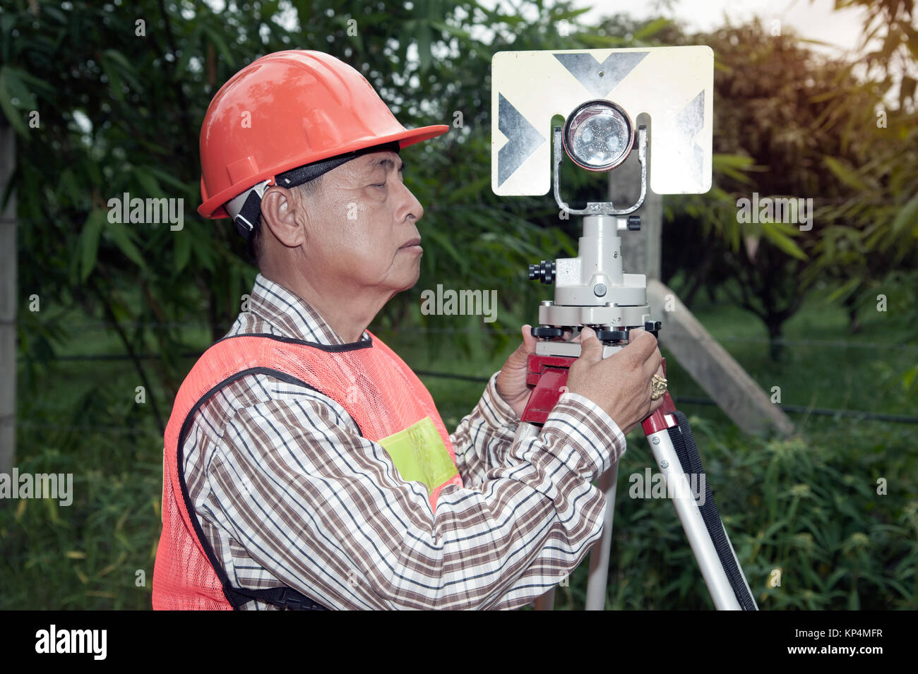 Surveyor or Engineer making measure by prism reflector on the street in ...
