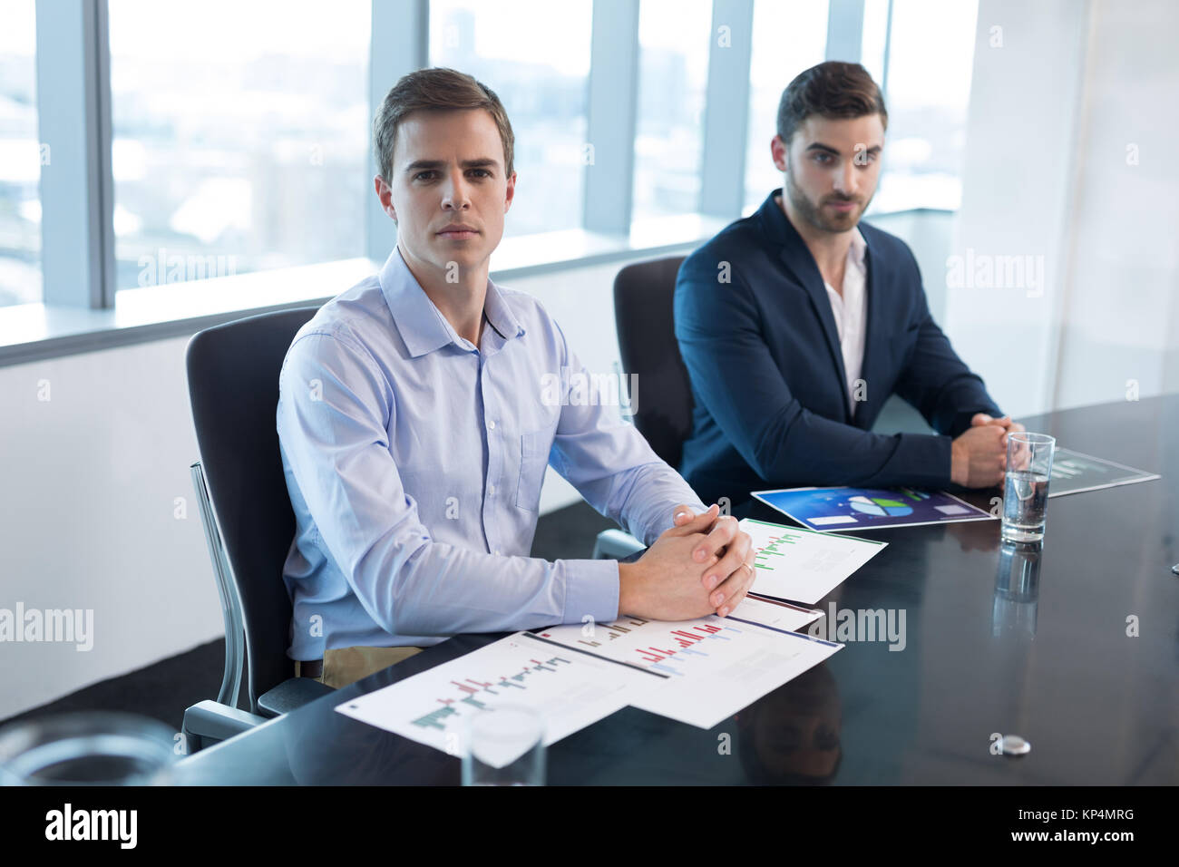 Portrait of male executives sitting at desk in boardroom Stock Photo ...