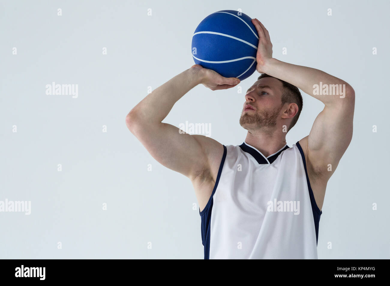 Basketball player ready to throw the ball against white baclground ...