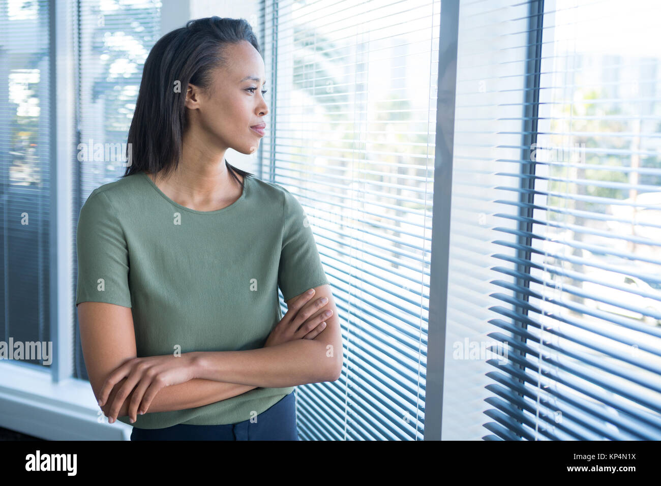Beautiful female executives looking through window in office Stock ...