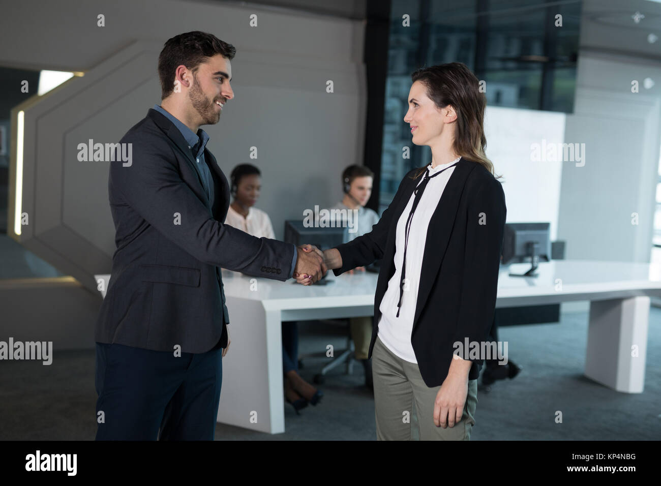 Smiling customer service trainer shaking hands in office Stock Photo ...