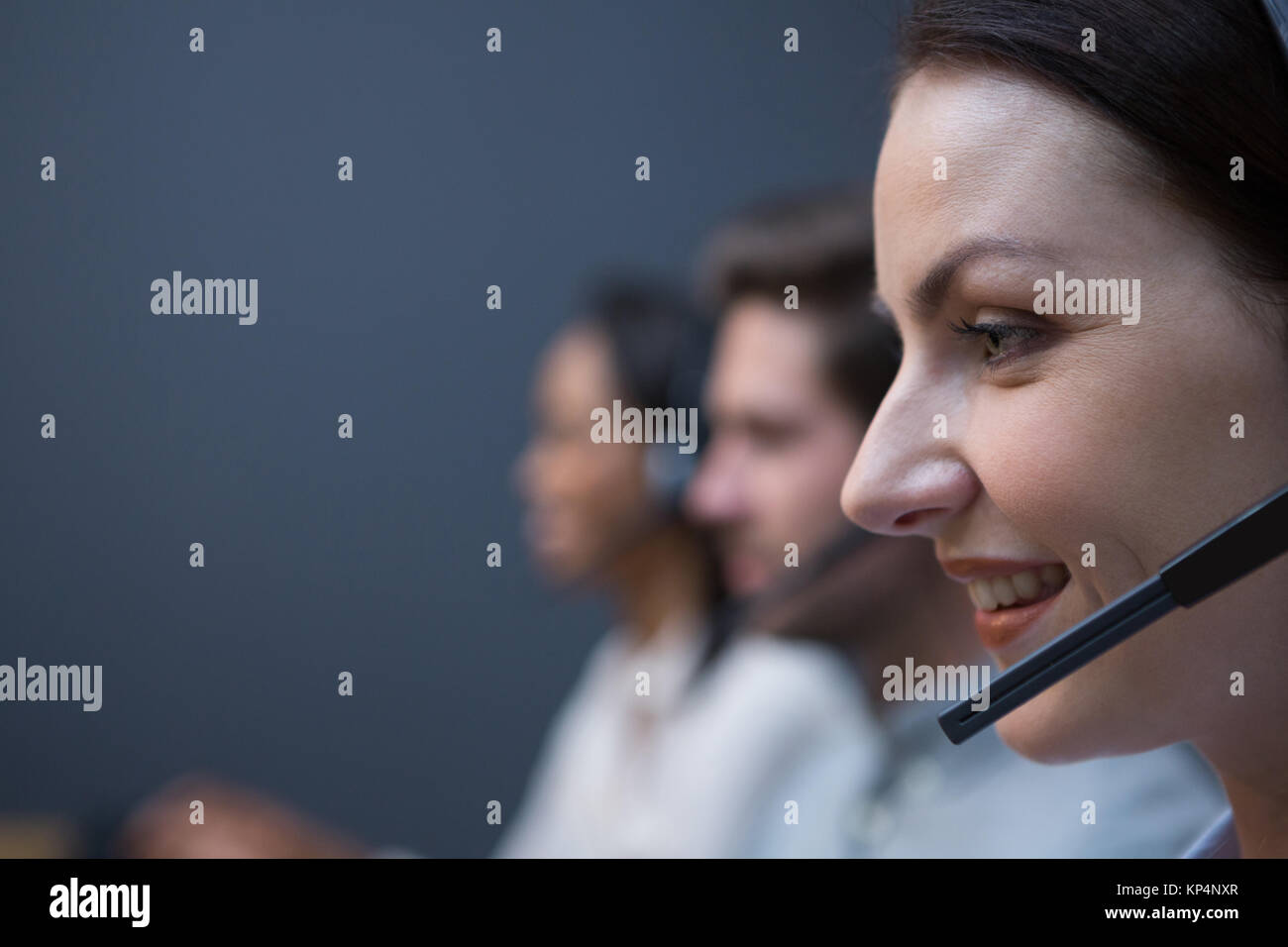 Female executive with headset using computer at desk in office Stock ...