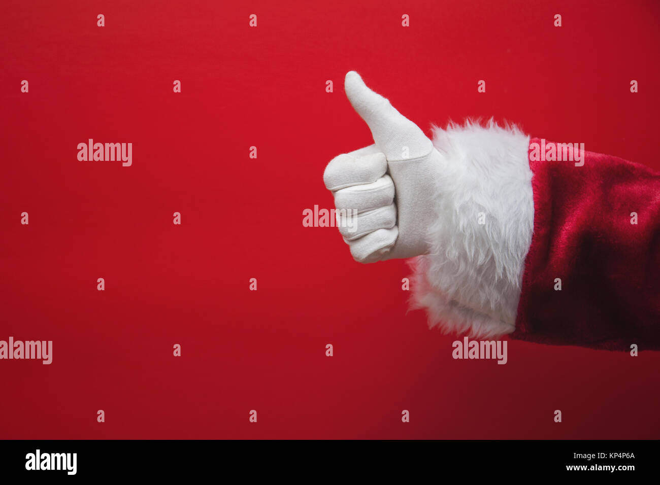 Santa Claus hand thumbs up against a red background Stock Photo - Alamy
