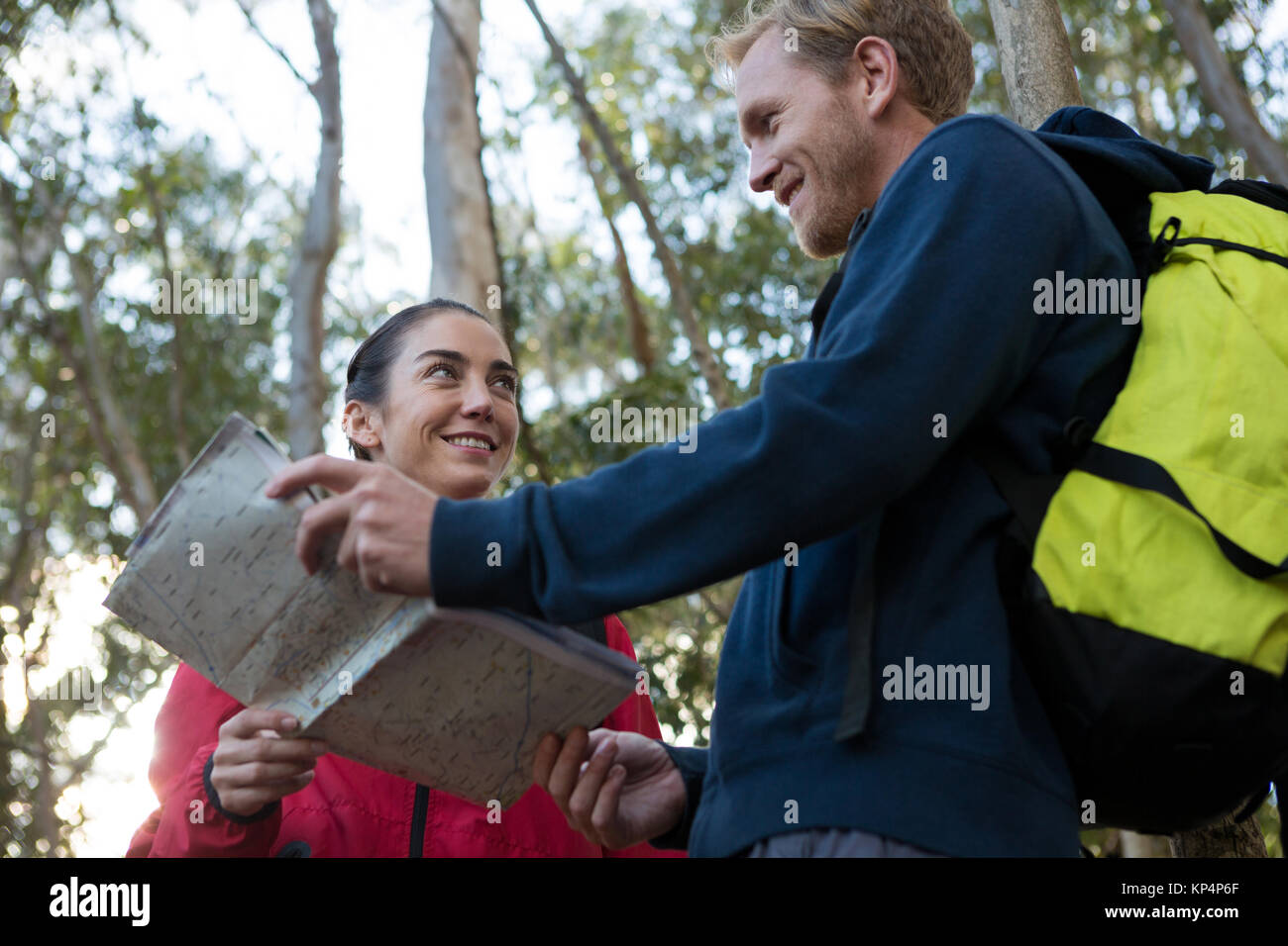 Woman and man hiker with backpack reading map in the forest Stock Photo ...