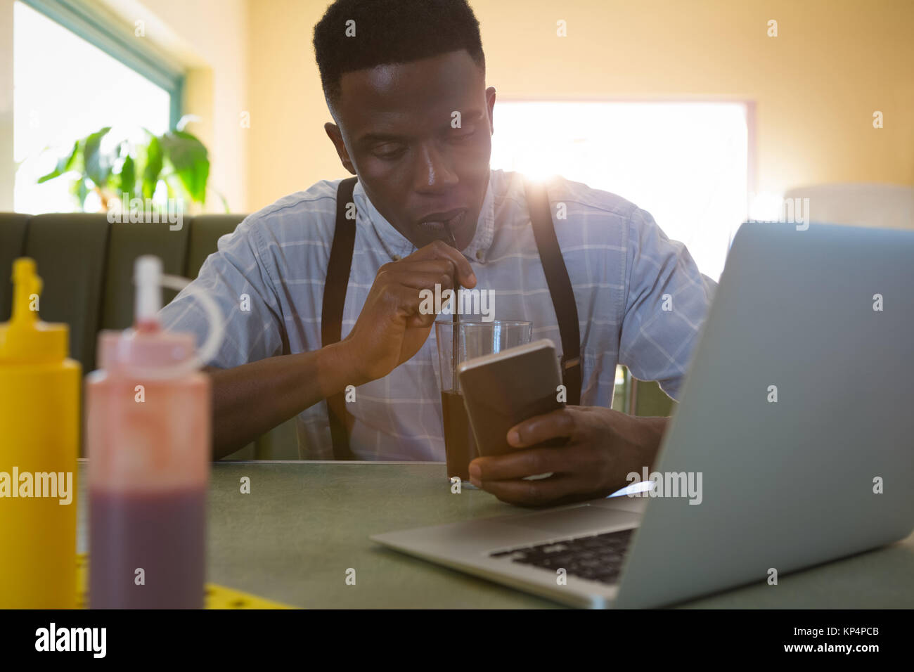 Man using mobile phone while having drinks in restaurant Stock Photo ...