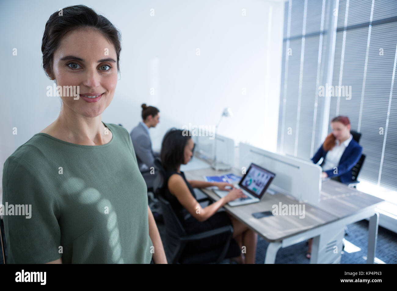 Smiling beautiful female executive looking at camera Stock Photo - Alamy