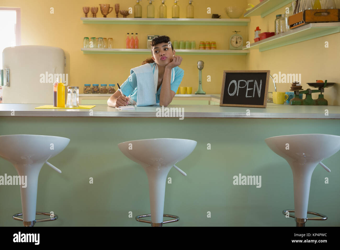 Thoughtful waitress standing at counter in restaurant Stock Photo - Alamy