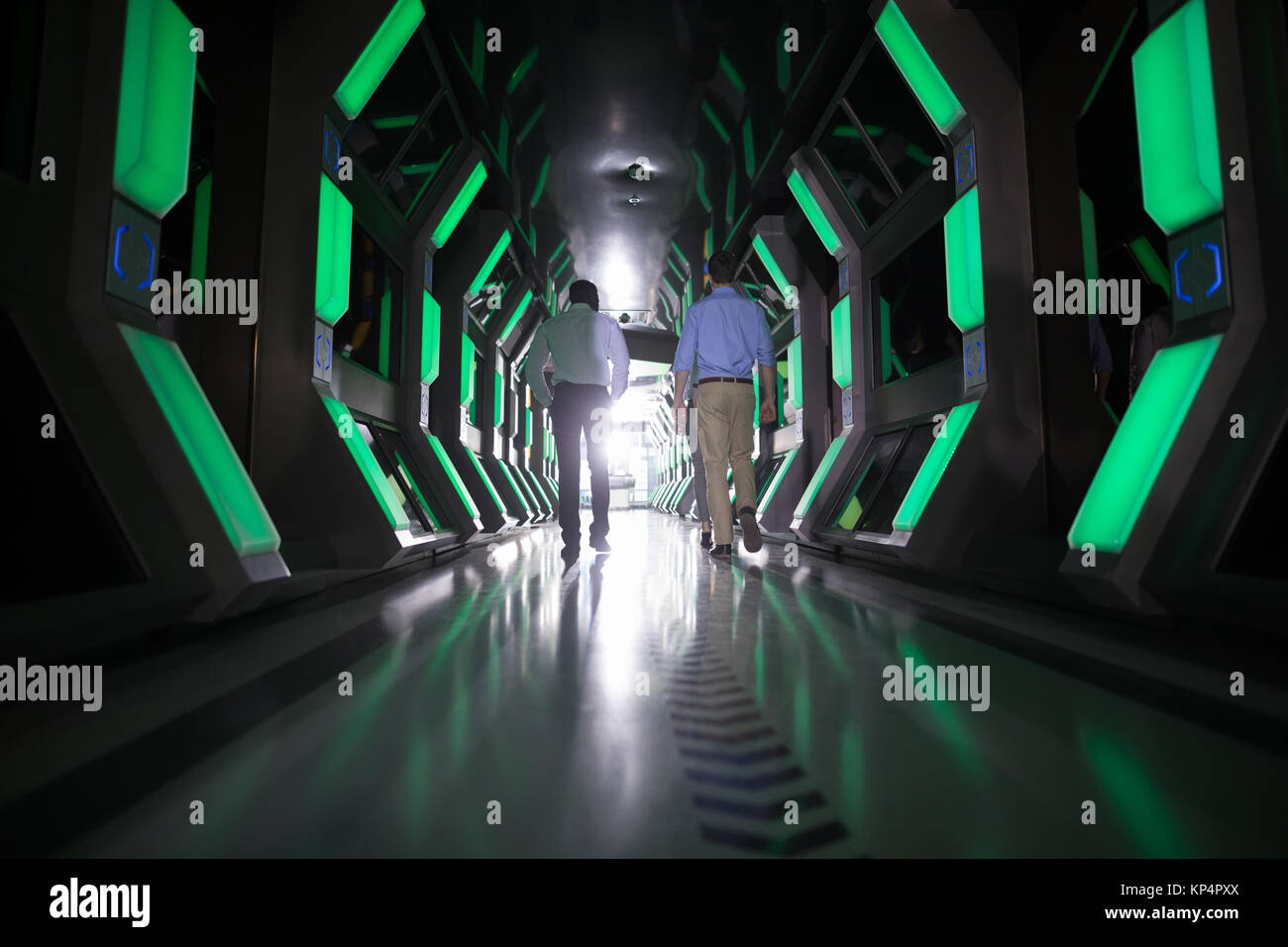 Rear view of male executive walking in futuristic office Stock Photo ...