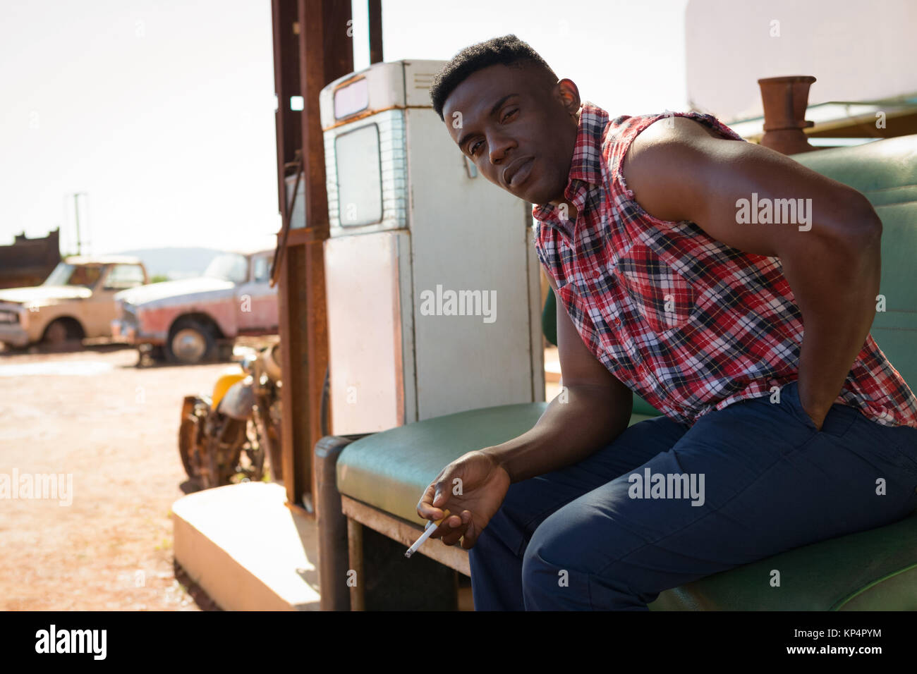 Portrait of man smoking cigarette at petrol pump station Stock Photo ...