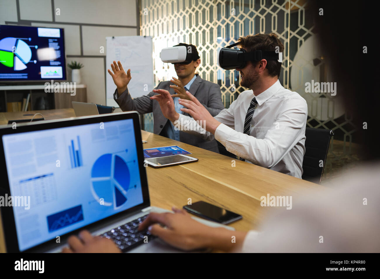 Businessmen using virtual reality headset in conference room at office ...