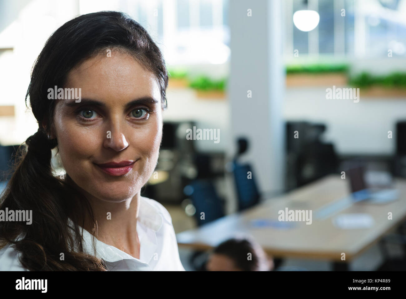 Smiling beautiful female executive looking at camera Stock Photo - Alamy