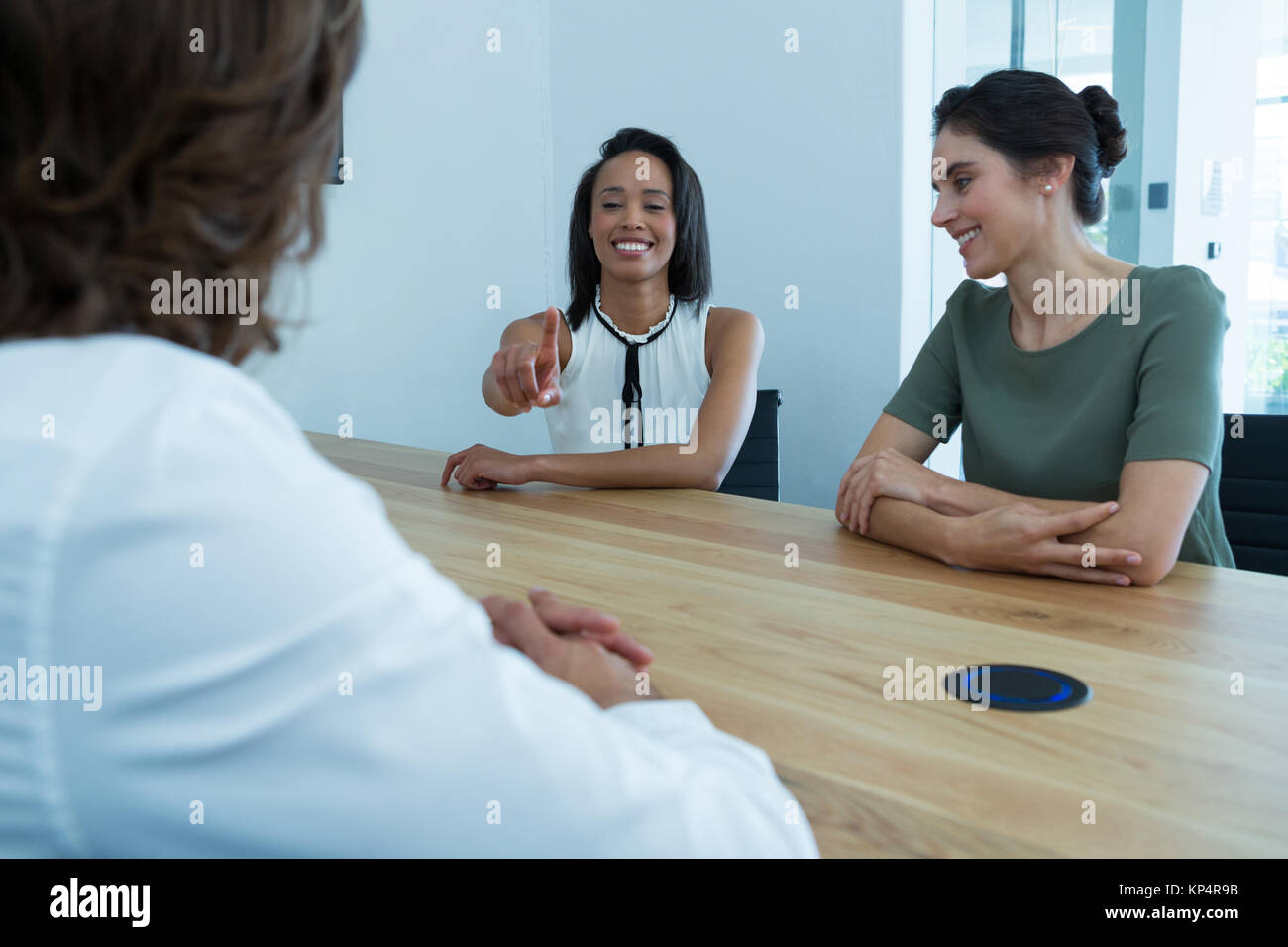 Happy group of executives discussing on project sitting around table in ...