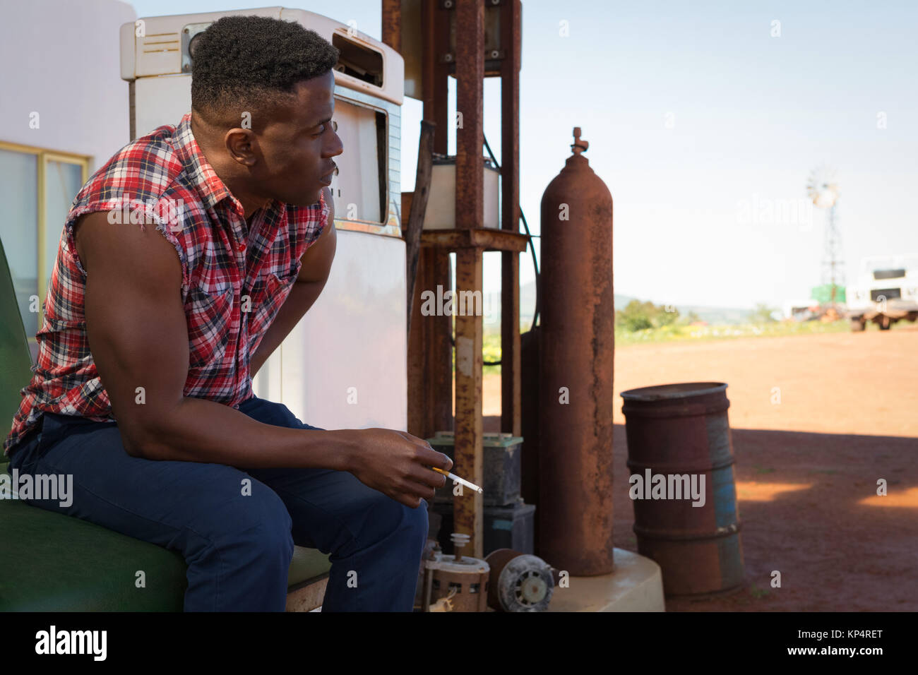 Thoughtful man smoking cigarette at petrol pump station Stock Photo - Alamy