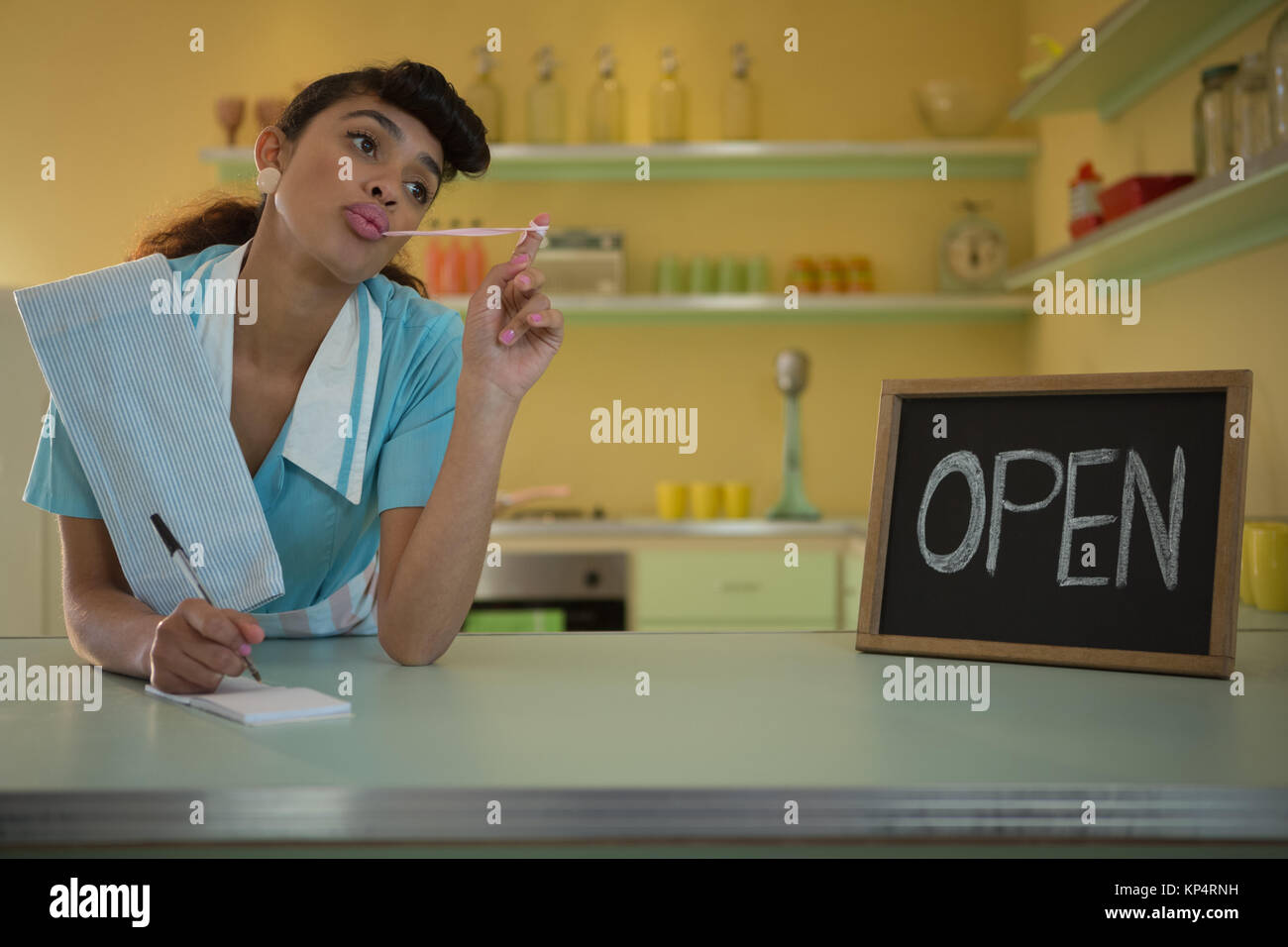 Thoughtful waitress standing at counter in restaurant Stock Photo - Alamy