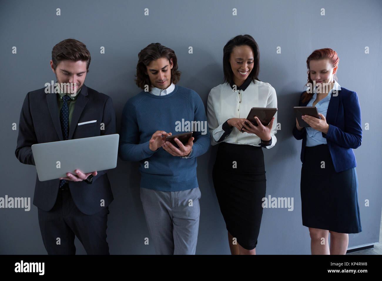 Team of business people using electronic devices in office Stock Photo ...