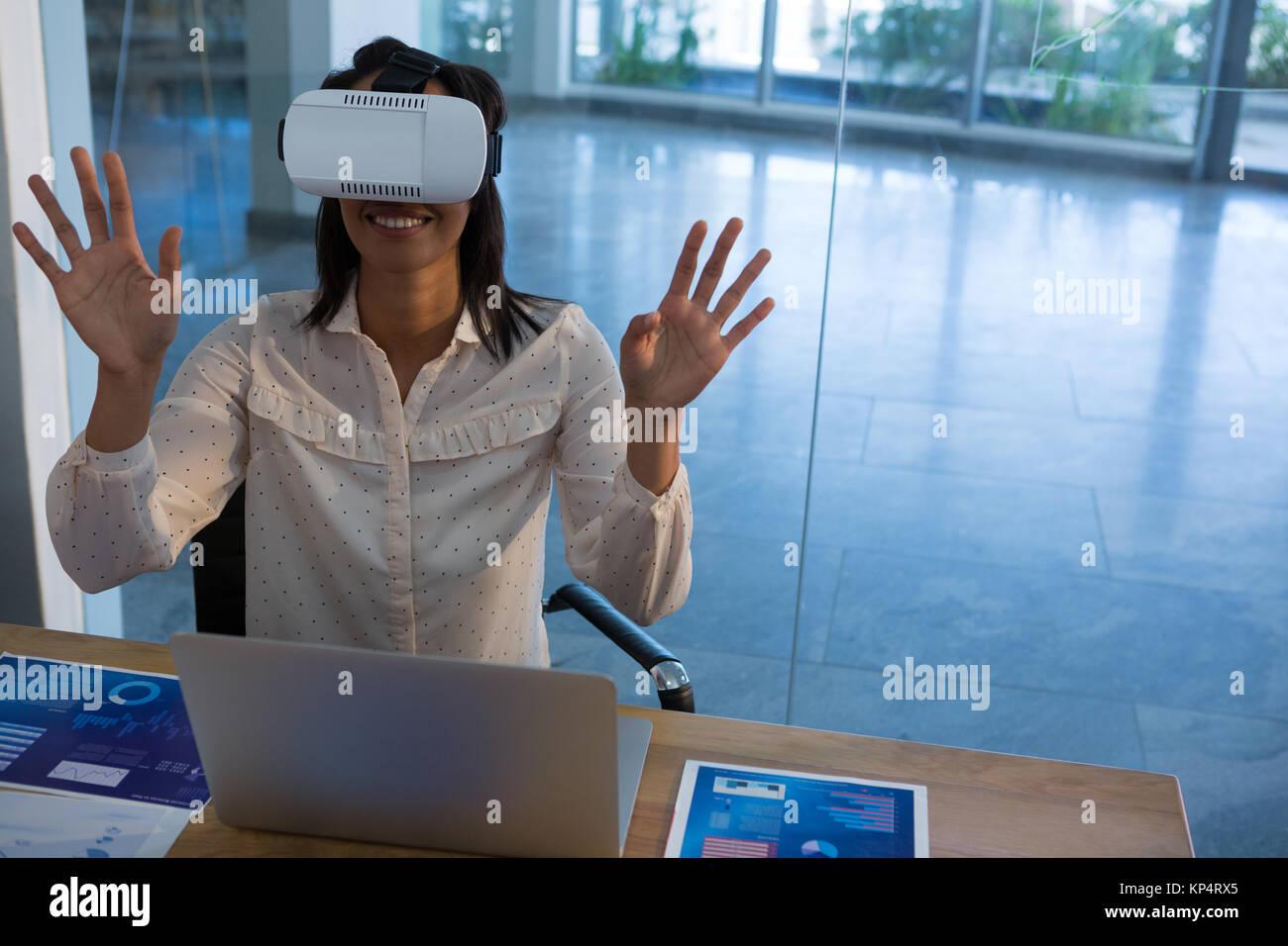 Female executive using virtual reality headset in office Stock Photo ...