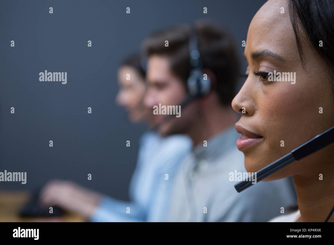 Female executive with headset using computer at desk in office Stock ...