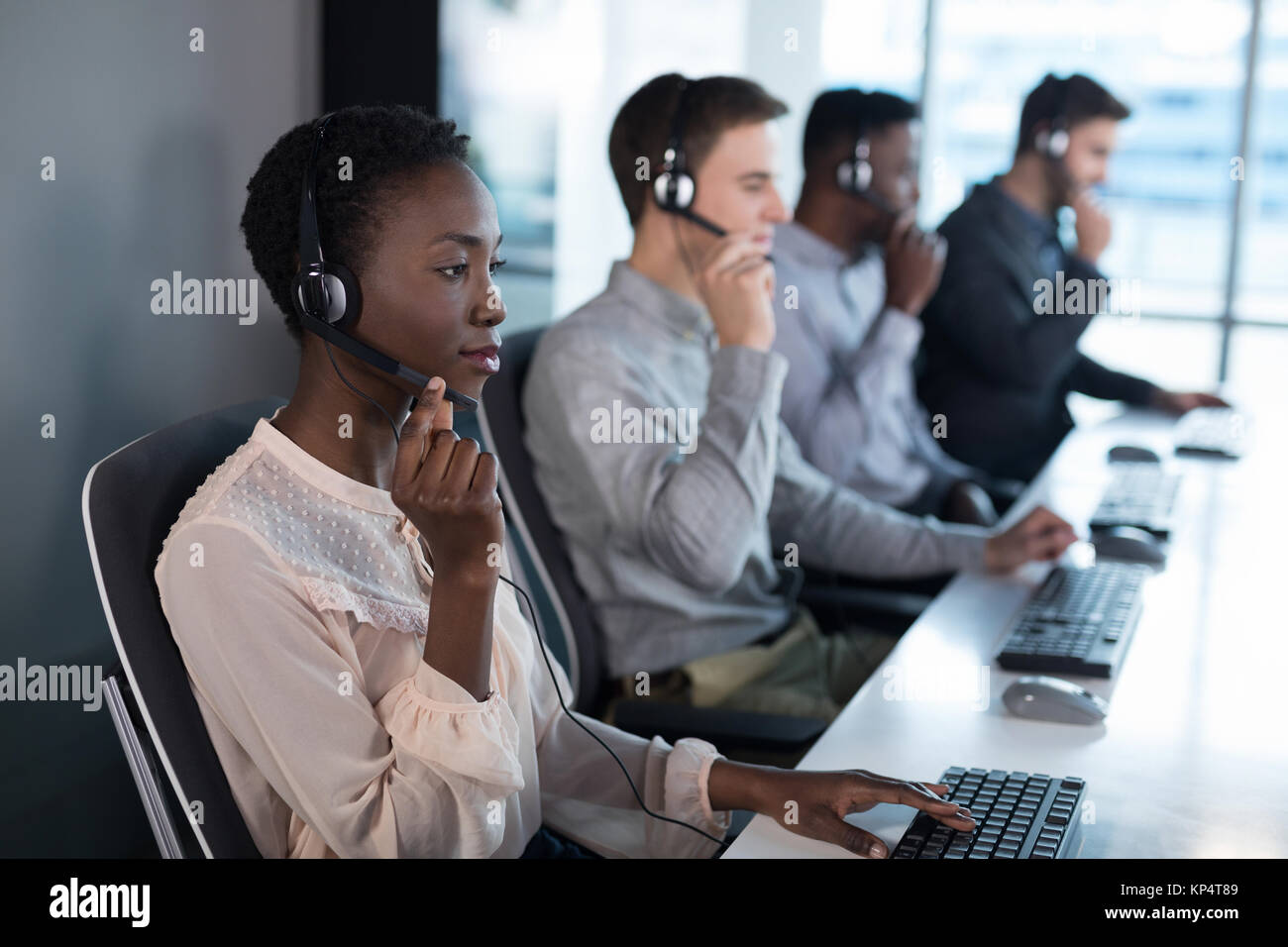 Attentive customer service executives working at office Stock Photo - Alamy