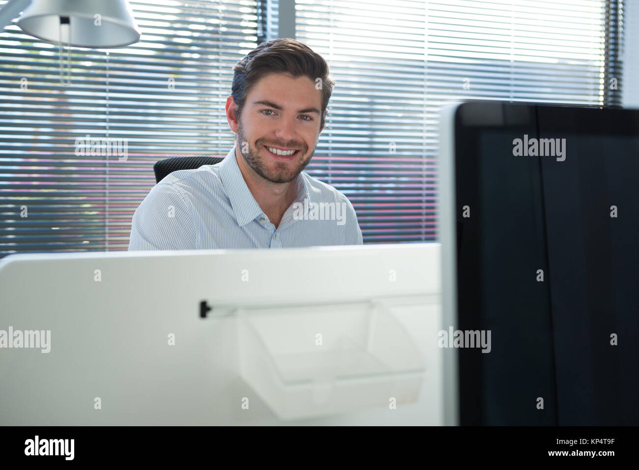 Smiling male executive looking at camera in the office Stock Photo - Alamy