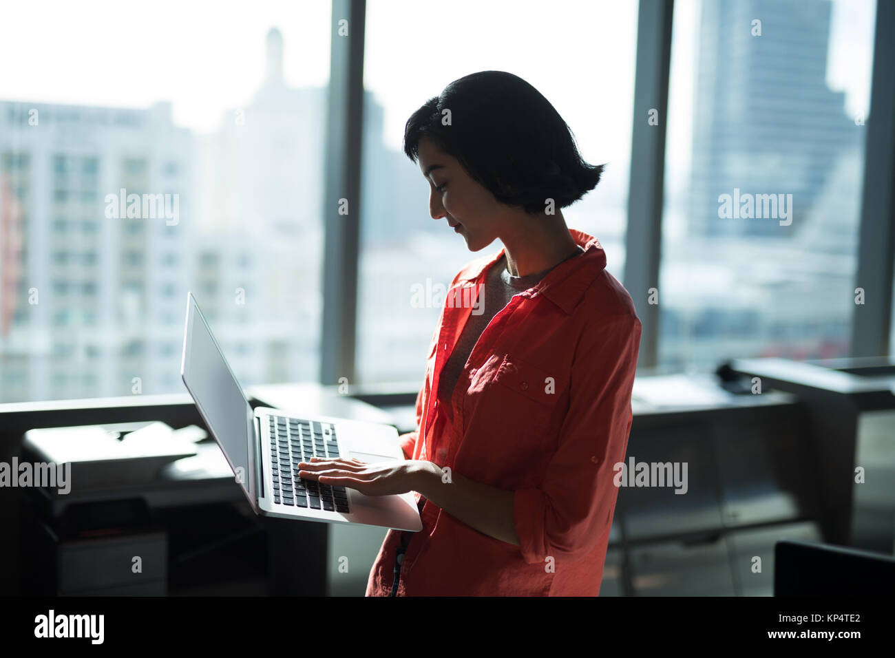 Female executive using laptop in office Stock Photo - Alamy