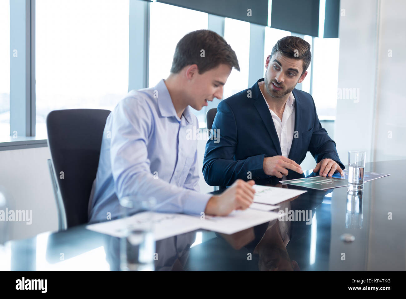 Male executives having discussion over graph in boardroom Stock Photo ...