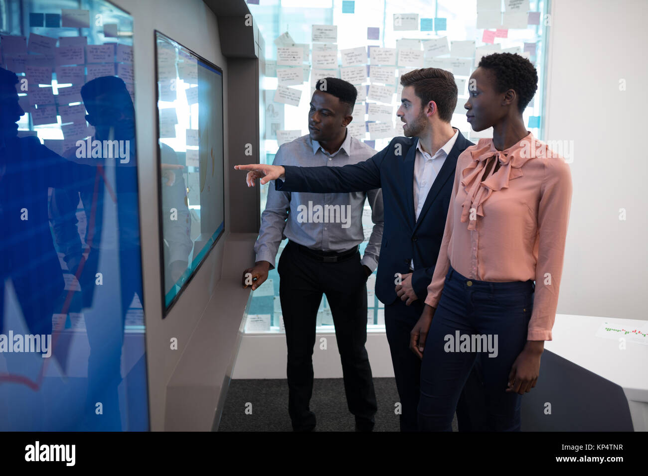 Male and female executives discussing over graph in boardroom Stock ...