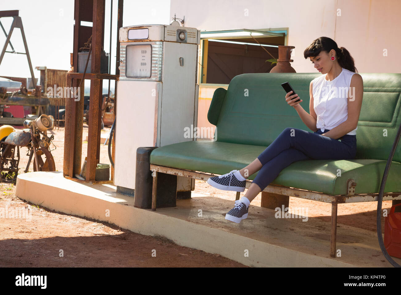 Young woman using mobile phone at petrol pump station Stock Photo - Alamy