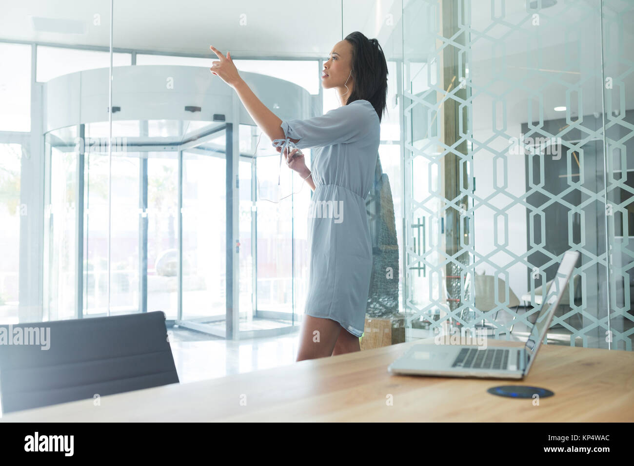 Female executive using invisible digital screen in office Stock Photo ...