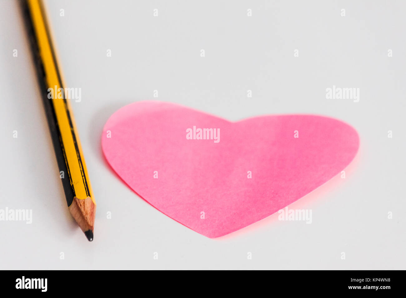 Pink heart note and pencil on white desk Stock Photo - Alamy