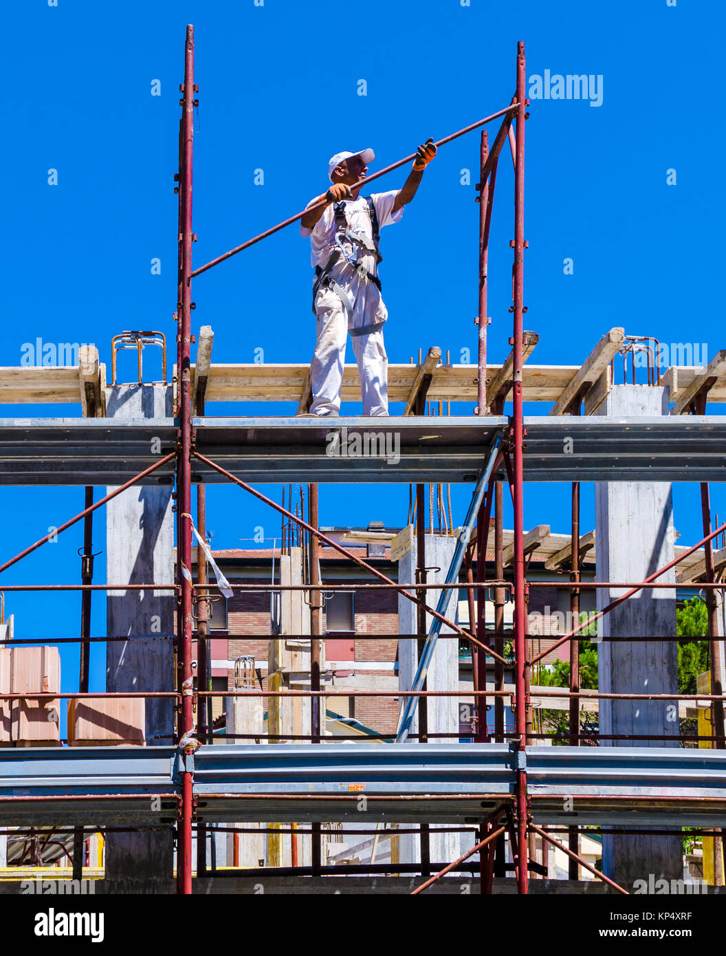 Builder Worker in safety protective equipment installing scaffolding ...