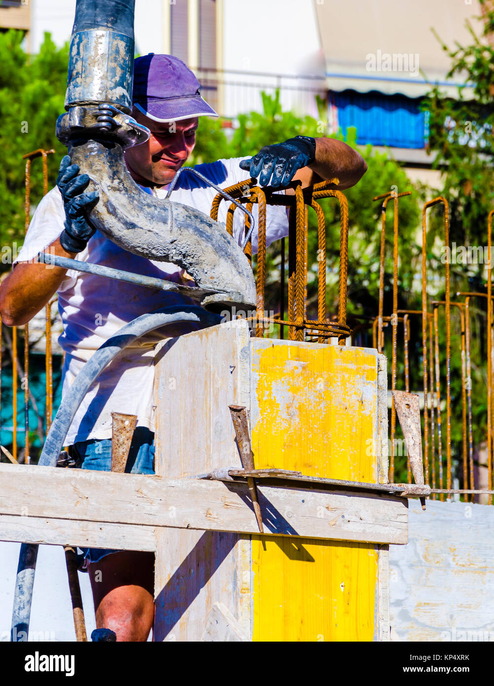 Construction worker casting column using hose from the elephant crane ...