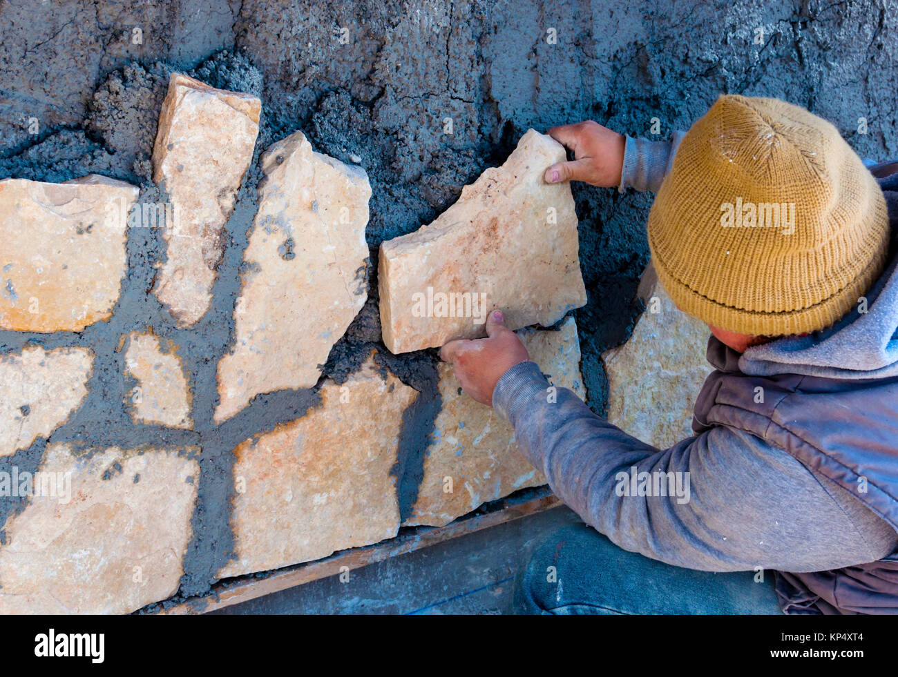 Worker stuck stone cladding on the outside facade Stock Photo - Alamy