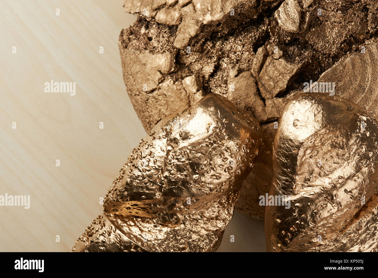 Gold bakery theme. Ready gold metal bread on wooden table above view ...