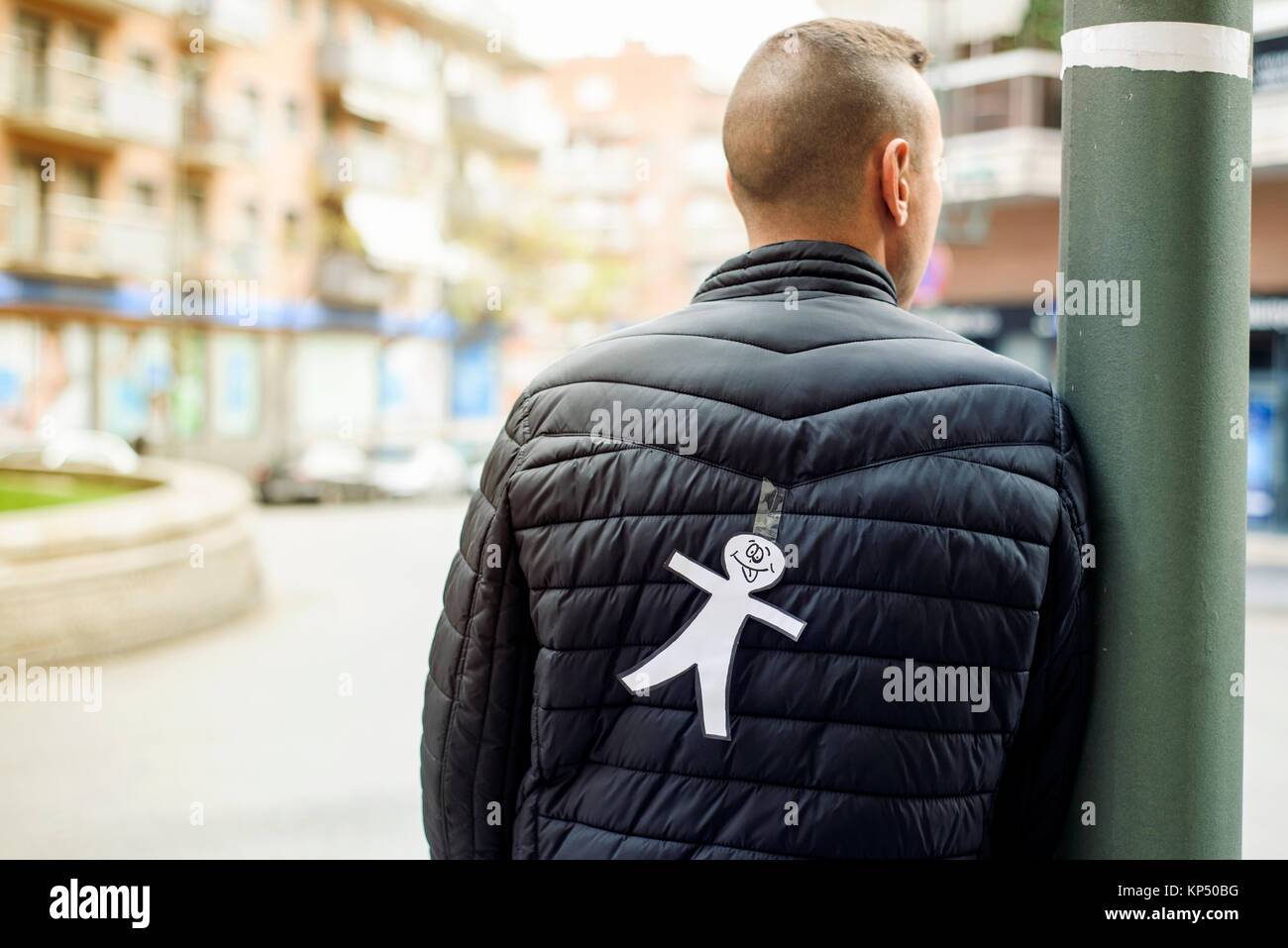 young man in the street with a paper man in his back as a prank for the ...