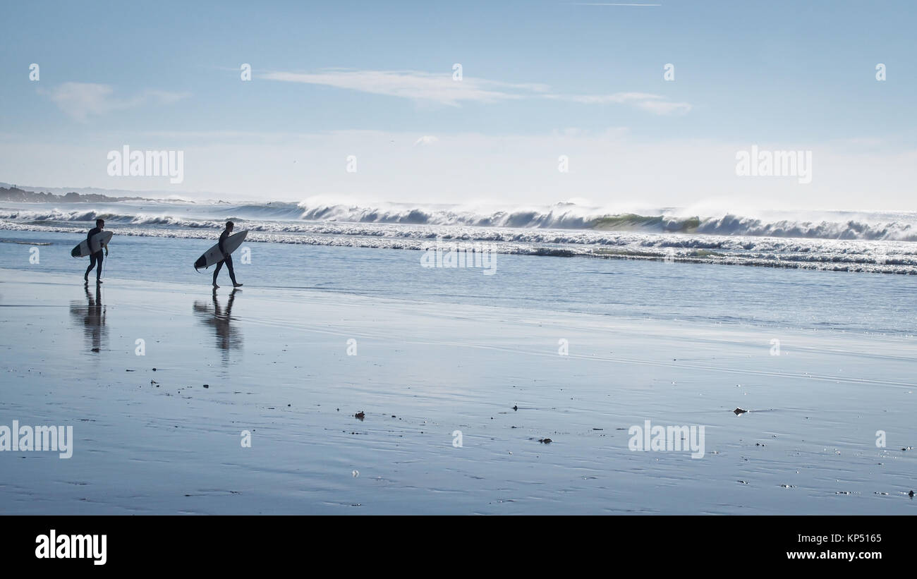 Surfers are walking on the beach in Atlantic Ocean surf at Porto ...