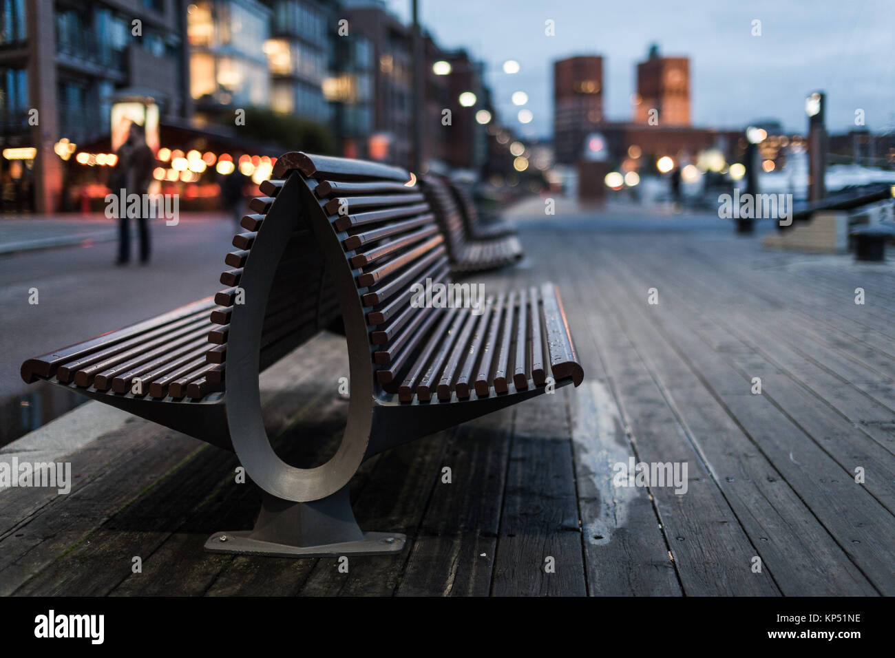A bench in the sunset on Aker Brygge in Oslo, Norway. In the back you ...