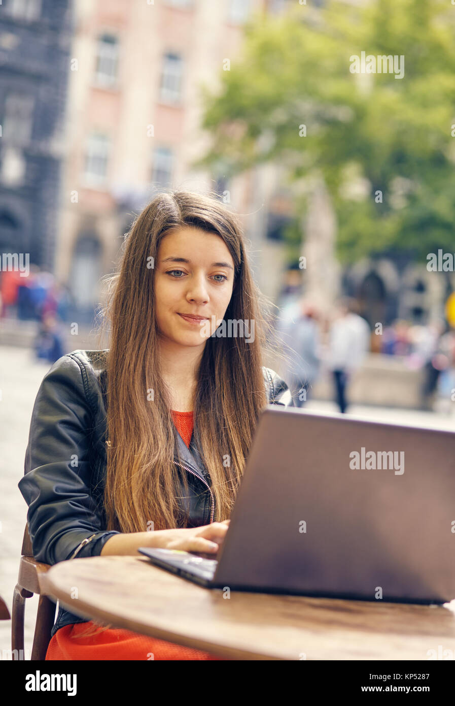 young woman sit down on wood table working on computer Stock Photo - Alamy