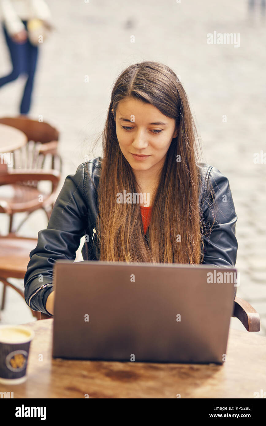 young woman sit down on wood table working on computer Stock Photo - Alamy