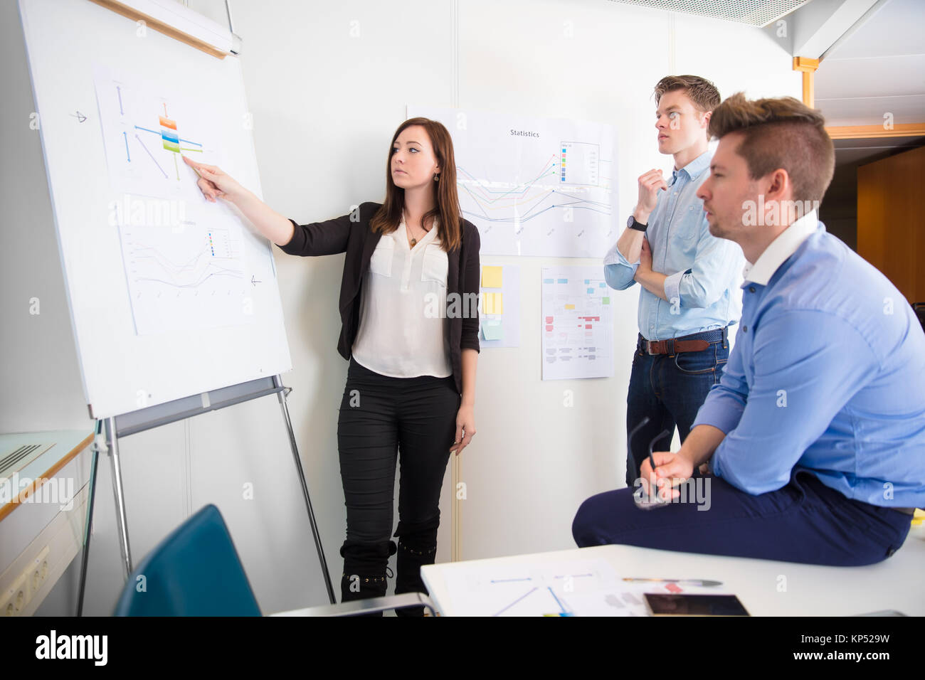 Confident Female Professional Explaining Chart To Colleagues Stock ...