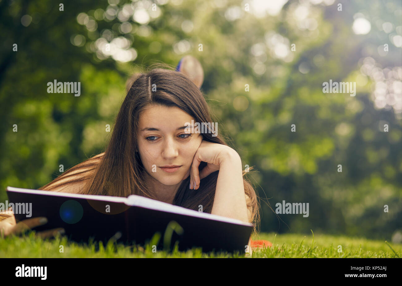 Beautiful woman reading book in nature Stock Photo - Alamy
